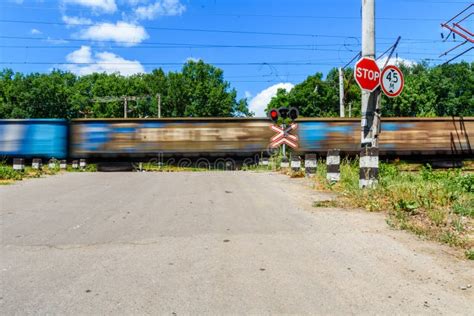 Railroad Crossing Sign And Blinking Semaphore In Front Of The Railroad Crossing Blurred Motion