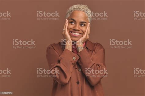 젊은 행복 한 아프리카 계 미국인 여자가 손바닥을 뺨에 대고 올려다 보며 미소를 짓는다 놀라움에 대한 스톡 사진 및 기타 이미지