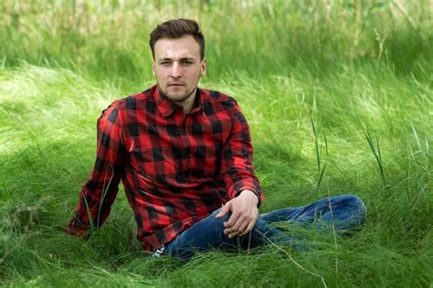 Premium Photo Trendy Guy Is Smiling And Resting On The Grass