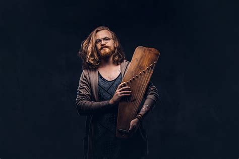 빨강 머리 Hipster 남성 긴 무성 한 머리와 전체 수염 캐주얼 옷을 입은 러시아 전통 악기gusli를 보유 하고있다 어두운