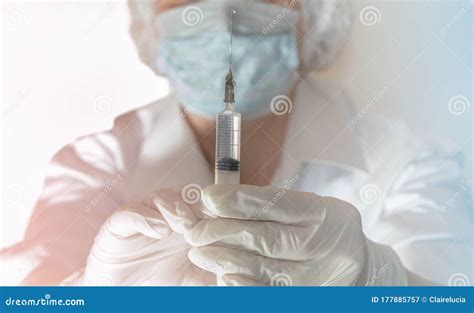 Een Arts In Medische Handschoenen Met Een Spuit Bereidt Een Injectie