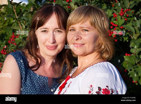 Happy Women With Flower Relaxes In The Grass With A Flower Stock Photo