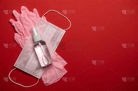 消毒瓶医用外科口罩和实验室手套 红色背景上的病毒防护设备COVID 中东呼吸综合征冠状病毒冠状