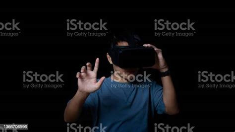 Vr 헤드셋을 착용한 스튜디오 초상화 남자가 검은 색 배경에 손가락으로 무언가를 만지고 있습니다 가상 현실의 안경 35 39세에
