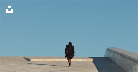 낮 동안 회색 콘크리트 바닥에 서 있는 검은 재킷을 입은 남자 사진 Unsplash의 무료 파랑 이미지