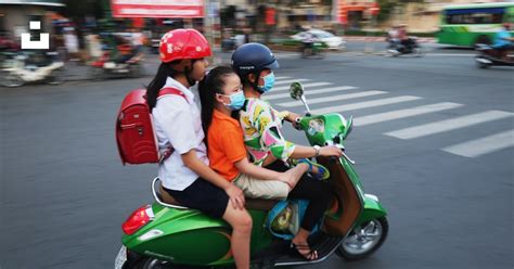 흰색 셔츠와 빨간 헬멧을 쓴 남자가 낮 동안 도로에서 녹색 모터 스쿠터를 타고 있다 사진 Unsplash의 무료 베트남 이미지