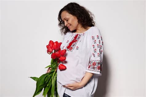 Gravid Woman Holding A Bunch Of Tulips Smiling Caressing Her Belly