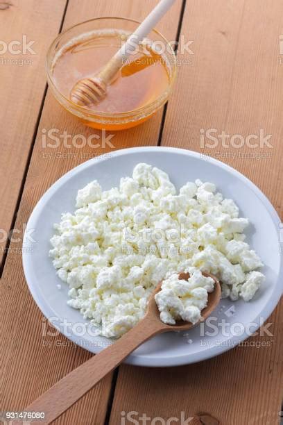 치즈 흰 접시 나무로 되는 숟가락 코 티 지 치즈와 꿀 나무 배경에서 신선한 코 티 지 치즈 사 우 어 크림 나무로 되는 숟가락