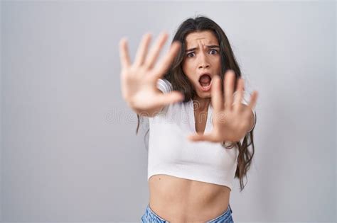Young Teenager Girl Standing Over White Background Afraid And Terrified
