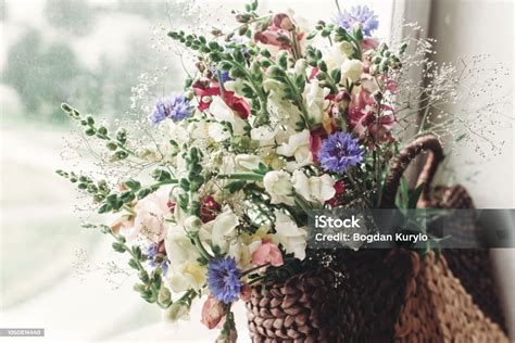 아름 다운 야생화가 소박한 흰색 창에 고리 버들 세공 가방에 햇빛 텍스트에 대 한 공간에서에서 갈색 바구니에 화려한 꽃 농촌