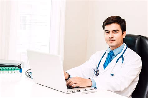 의사가 웃 고 청진 기 Hospitalhealthcare 및 의학에서 노트북 컴퓨터에 카메라를 보고 개념에 대한 스톡 사진 및
