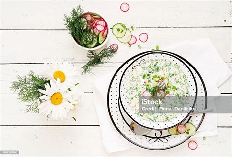 신선한 오이로 차가운 수프 나무 배경에 그릇에 요구르트와 함께 무 전통적인 러시아 음식okroshka입니다 채식 식사입니다