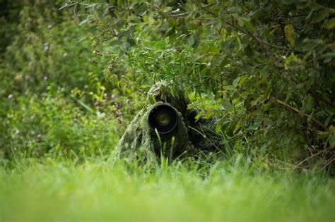 Premium Photo Wildlife Photographer With A Large Lens Hiding Under A