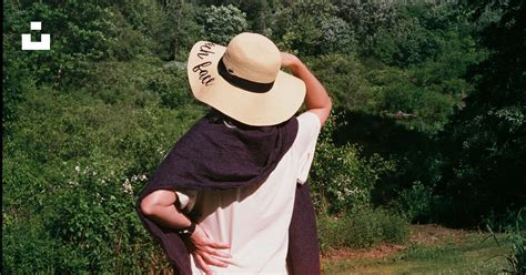 낮 동안 푸른 잔디밭에 서 있는 흰 셔츠와 갈색 모자를 쓴 여자 사진 Unsplash의 무료 미국 이미지