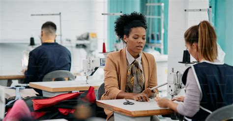 아프리카 계 미국인 의류 디자이너는 섬유 공장의 생산 라인에서 일하는 여성 재단사와 의사 소통합니다 사진 Unsplash의 세르비아 이미지