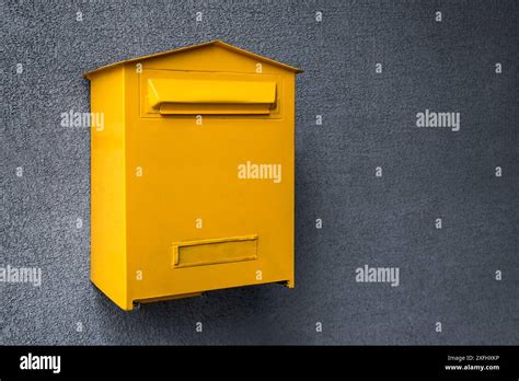 Mockup Of Vintage Blank Rectangular Yellow Mailbox On Bumpy Gray Wall Closeup Perspective View
