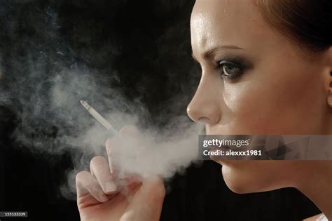 Young Woman In Profile Smoking Exhaling Smoke Through The Nose High Res