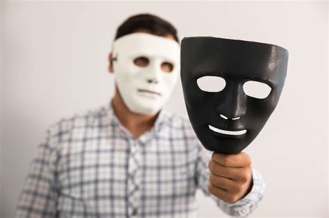 Premium Photo Man Wearing White Mask Holding Black Masks In His Hand