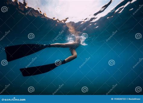Sporty Woman Freediver With Fins Glides Underwater In Sea Freediving