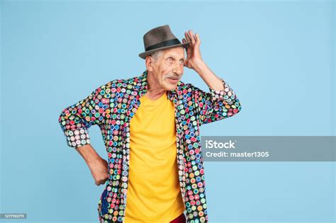 파란 배경에 고립 된 세련된 모자를 입은 선임 힙스터 남자 기술과 즐거운 노인 라이프 스타일 컨셉 65 69세에 대한 스톡 사진