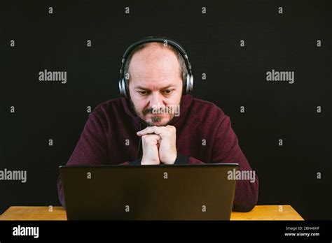 Man In Hoodie And Headphones On Head Sitting Behind The Laptop Confused Unsuccessful Black