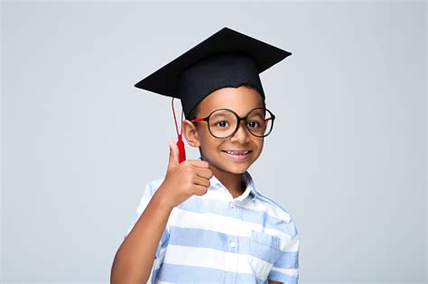 회색 배경에 엄지 손가락을 보여주는 졸업 모자를 쓴 어린 아프리카 계 미국인 소년 검은색에 대한 스톡 사진 및 기타 이미지 검은색 교육 귀여운 Istock