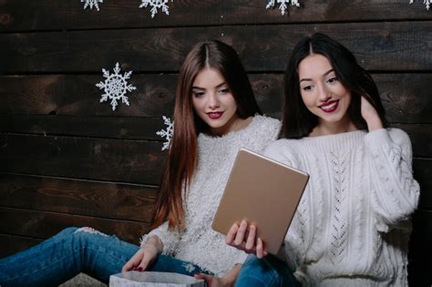 Deux Belles Femmes Assises Sur Le Sol Avec Une Tablette Photo Gratuite