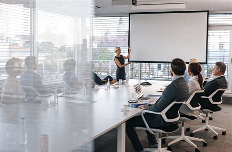 성숙한 Ceo는 보드 룸에서 프로젝션 스크린을 통해 비즈니스 프리젠 테이션을 제공합니다 프리젠테이션 연설에 대한 스톡 사진 및 기타 이미지 프리젠테이션 연설 회의실