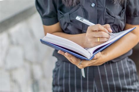 Jeune Femme Asiatique Debout Dans Le Parc Et écrit Un Cahier Concept D