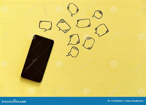 Smartphone On Yellow Background With Text Bubbles Around Messag Stock
