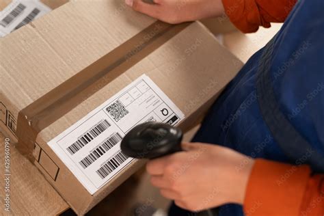 Female Hands Scanning Barcode On Delivery Parcel Worker In Factory Warehouse Scanning Labels On