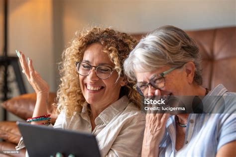 디지털 태블릿에 소셜 미디어를보고 집에서 앉아 노인 어머니와 아름다운 성인 딸 웃음 즐겁게 노인에 대한 스톡 사진 및 기타 이미지 Istock