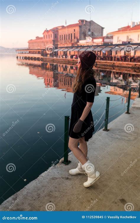 Young Woman In Hat And Cute Summer Dress Standing On The Pier With