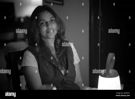 A Black And White Portrait Of A Beautiful Indian Girl Sitting In A Room