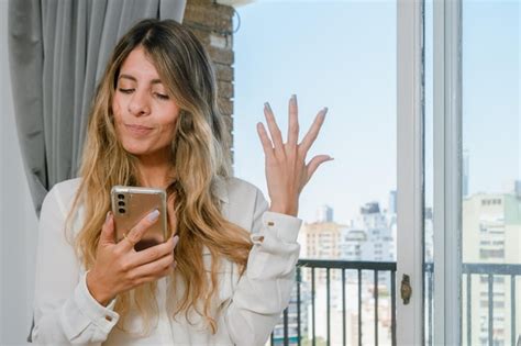 Jeune Femme Colombienne Debout à La Maison Lisant Des Messages Sur Son
