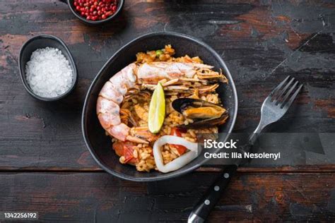 오래된 어두운 나무 테이블에 검은 그릇에 해산물과 닭고기와 전통 스페인 빠에야 상단 보기 0명에 대한 스톡 사진 및 기타 이미지