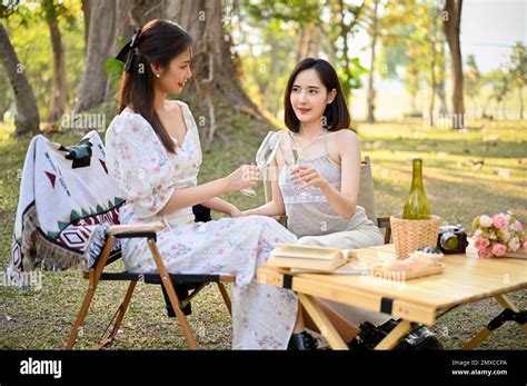 Two Beautiful Asian Women In Lovely Dresses Enjoying Afternoon Picnic