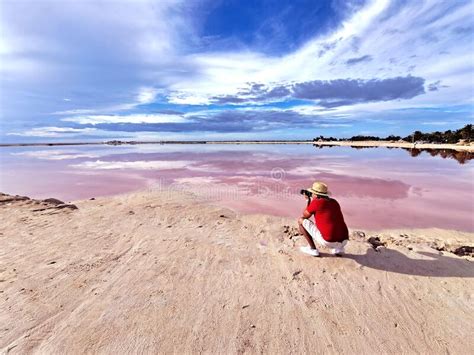 Photographer Man Takes Pictures Next To The Pink Colored Lagoon With A