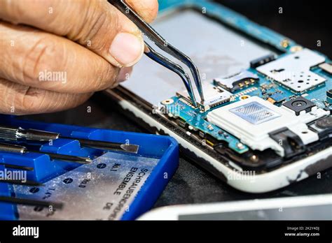 Technician Repairing Inside Of Mobile Phone By Soldering Iron