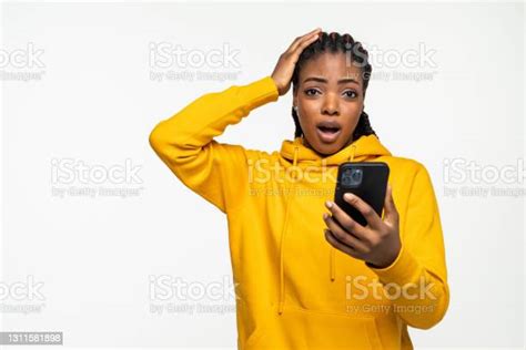흰색 배경에 고립 된 Sms 메시지를 입력 휴대 전화를 사용하여 젊은 아프리카 계 미국인 여성을 충격 사람들 라이프 스타일 개념