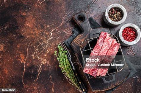 야키니쿠를 위한 그릴에 프리미엄 생 슬라이스 와규 쇠고기 A5 스테이크 일본 음식 어두운 배경 맨 위 보기입니다 복사 공간