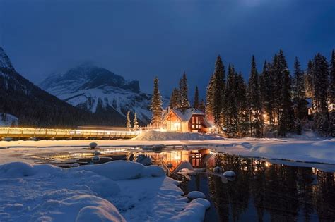 Premium Photo Emerald Lake With Wooden Lodge Glowing In Snowy Pine