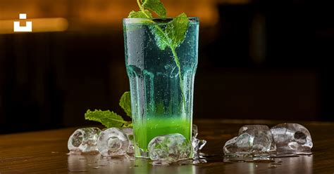 테이블에 얼음 조각이 든 녹색 음료 사진 Unsplash의 무료 칵테일 이미지