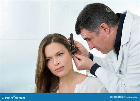 Doctor Ent Checking Ear With Otoscope To Woman Patient Royalty Free