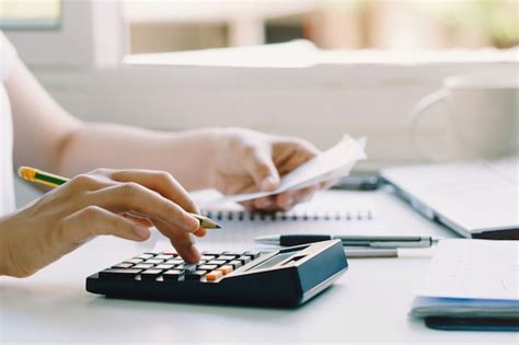 Mujeres que usan la calculadora para calcular las facturas domésticas en el hogar Foto Premium