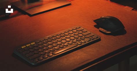 机の上に置かれたコンピューターのキーボードとマウスの写真 Unsplashの無料茶色写真