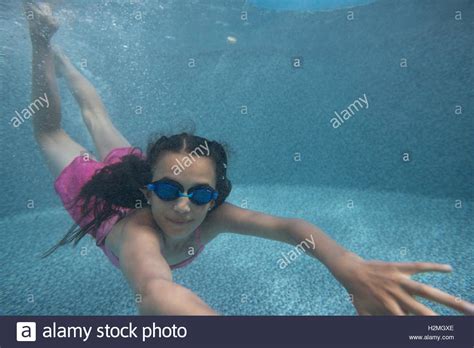 Portrait Girl Wearing Goggles Swimming Underwater In Swimming Pool