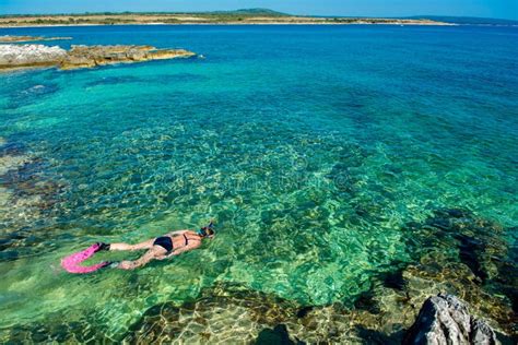 Милая женщина в бикини Snorkeling через воду бирюзы на побережье