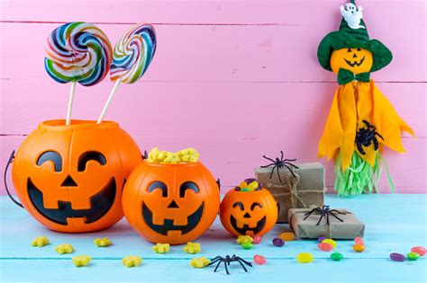 트릭 또는 치료 텍스트에 대한 복사 공간이 핑크와 블루 나무 배경에 할로윈 잭 O랜턴 사탕과 무지개 롤리팝 플랫 레이 상단 보기