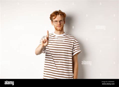 Junger Mann mit roten Haaren und Brille der verbotene Finger schüttelt